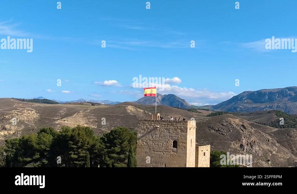 Spanish flag waving on top of ancient castle with landscape in ...