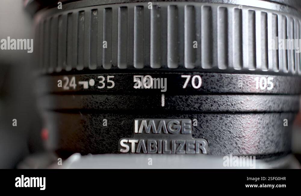 An extreme close up shot as the zoom ring of a telephoto camera lanes ...