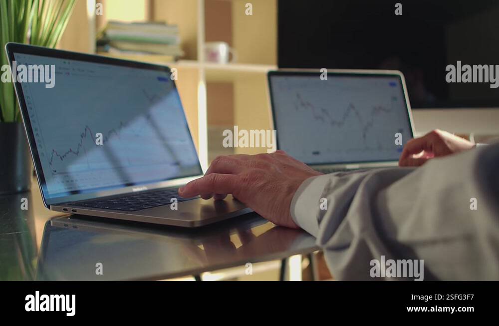 A trader walks up to two laptops displaying charts of the bitcoin ...