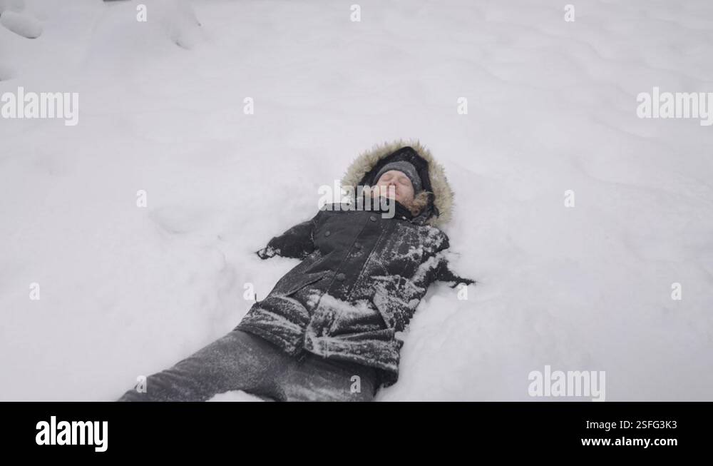 Man Jumping into snow and then making Snow Angels in slow motion in the ...