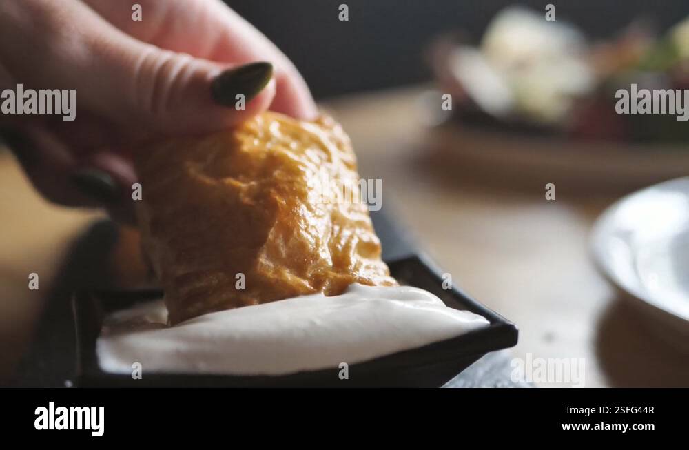 Dip puff pastry with minced meat in sour cream sauce..Snack from puff ...