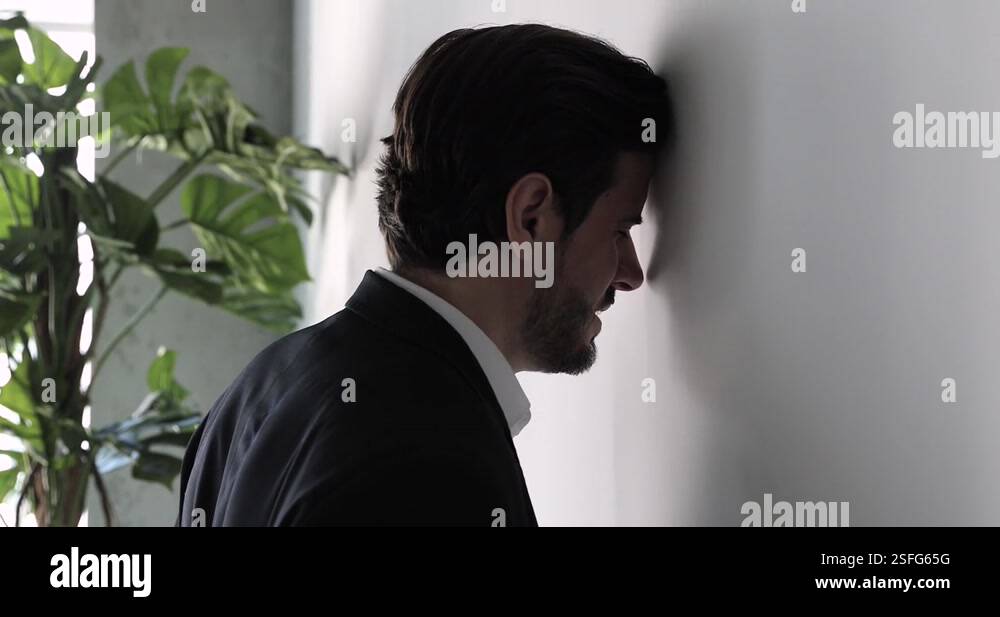 Stressed desperate businessman stand in office lean head on wall Stock ...