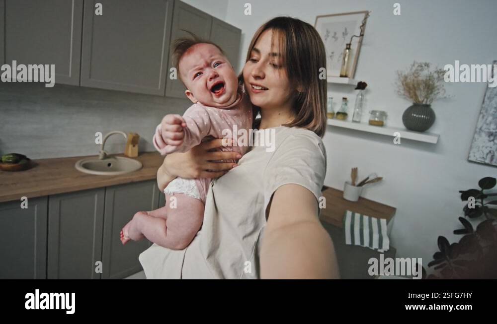 Woman with Crying Baby in Kitchen Stock Video Footage - Alamy