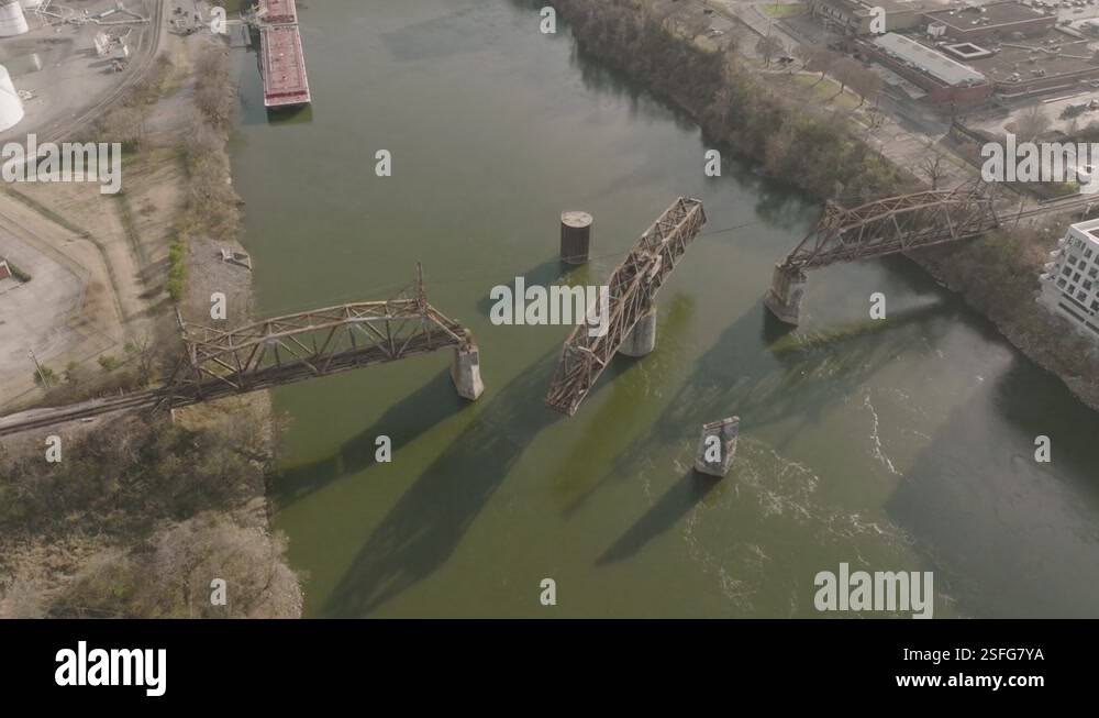 Railroad bridge slowly turning to let barge pass through on river in ...