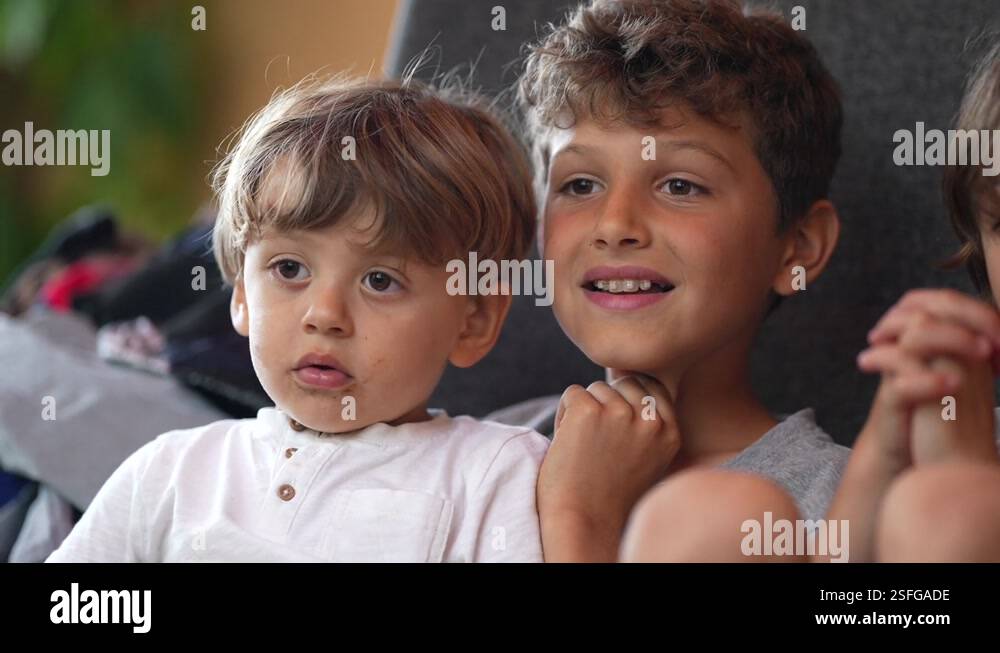 Two little brothers together watching movie entertainment closeup faces ...