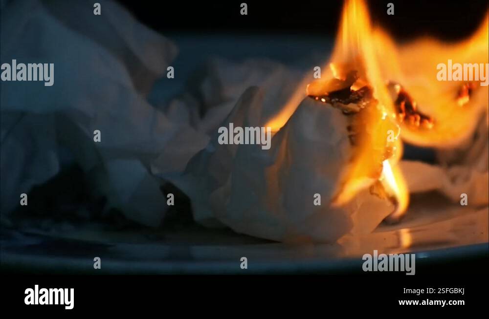 close-up fire from the lighter igniting and burning tissue in the hand ...