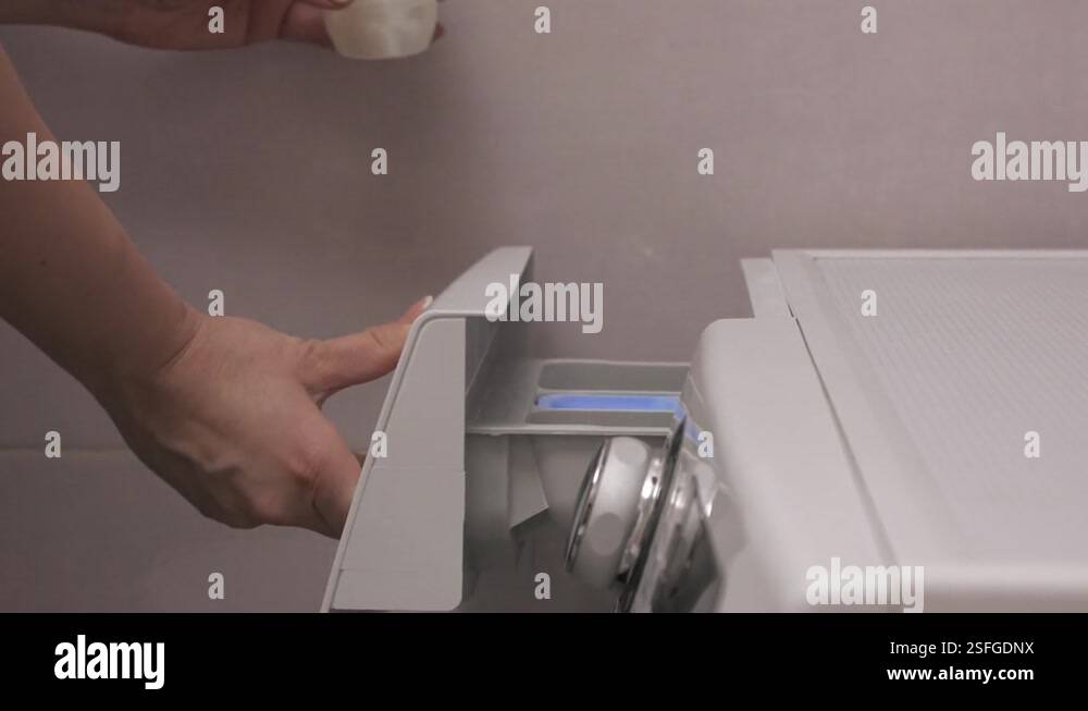 Liquid gel for washing clothes is poured into compartment of washing ...