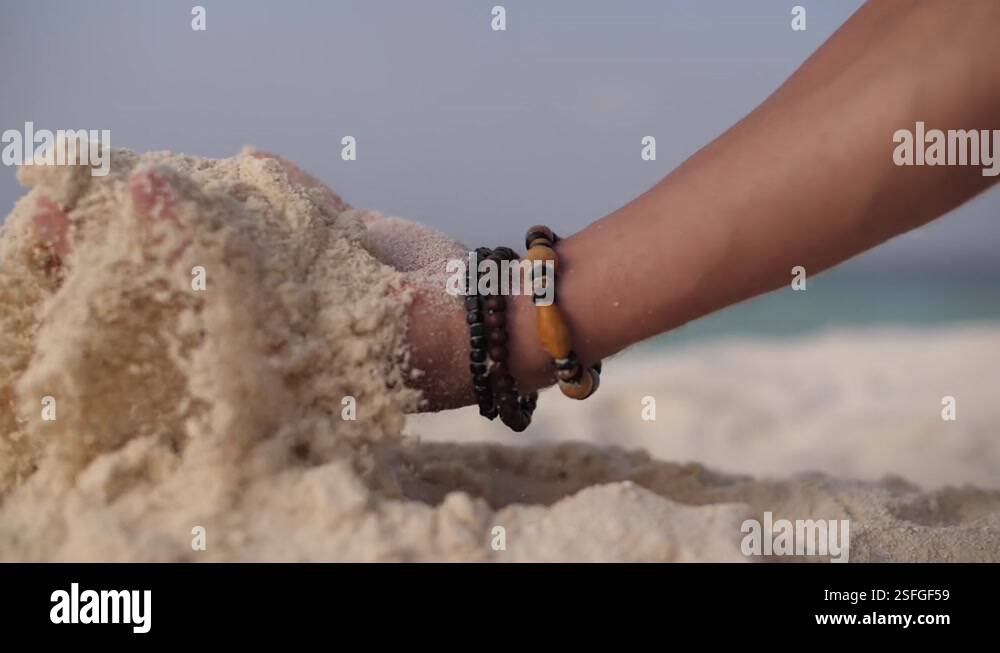 SLOW MOTION: Unrecognizable man grabs a handful of dry sand and lets it ...