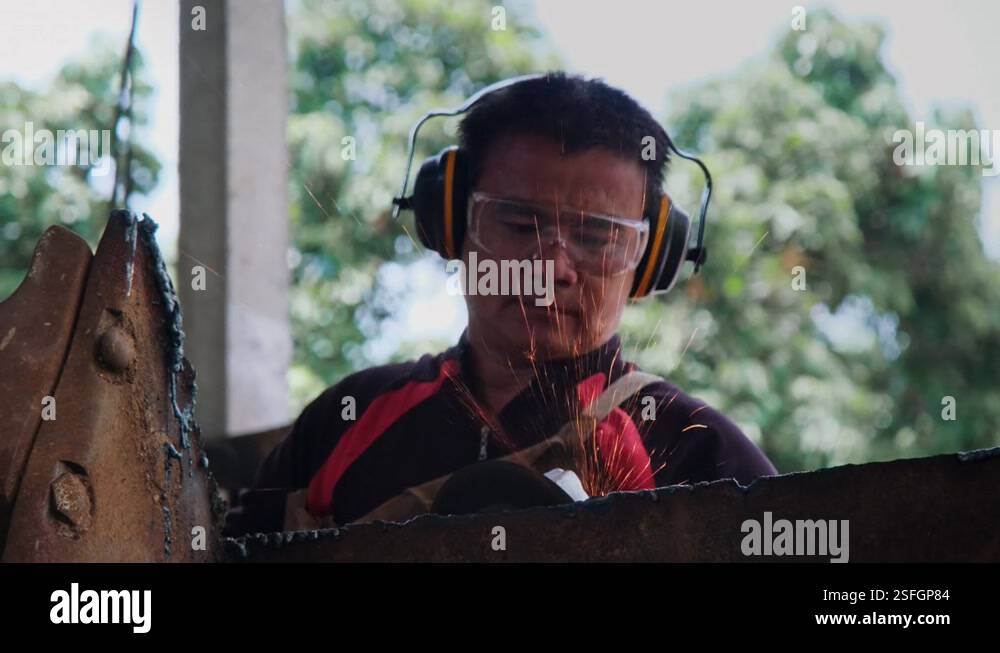 Man work in home workshop with angle grinder, goggles and construction ...