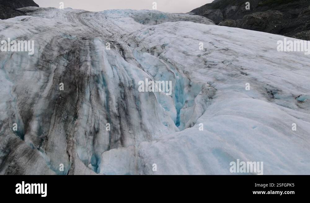 Aerial view of details on a thawing Glacier with sooty ice and glacial ...