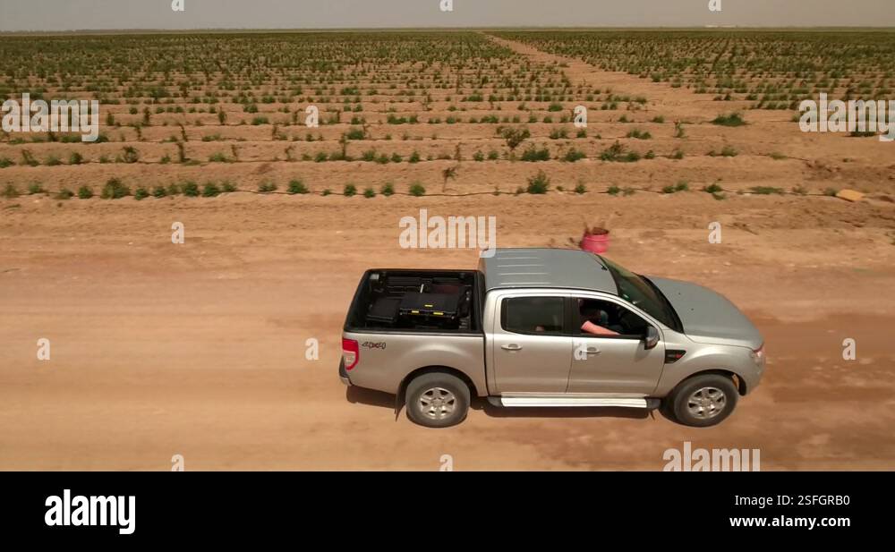Aerial Shot Of People Driving Pull Up Truck In Agricultural Field On ...