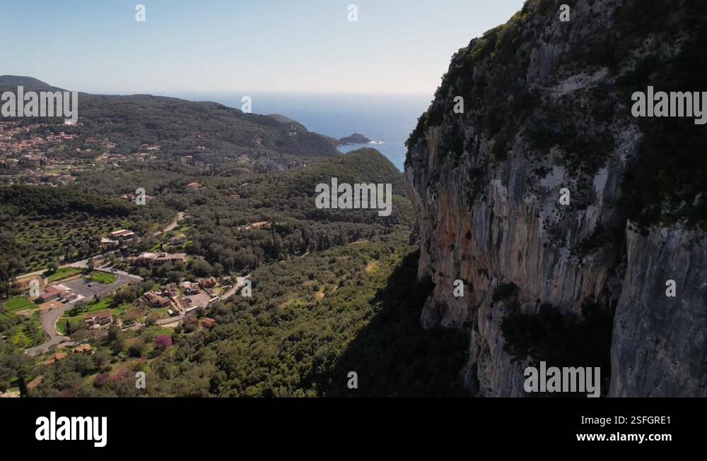 Forward droneshot along steep cliff of foresty green mountain in Greece ...