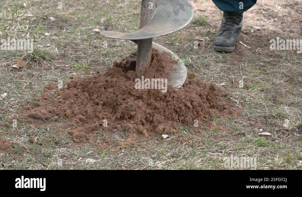 Drill bit for drilling soil close up. Drilling a hole into ground at a ...