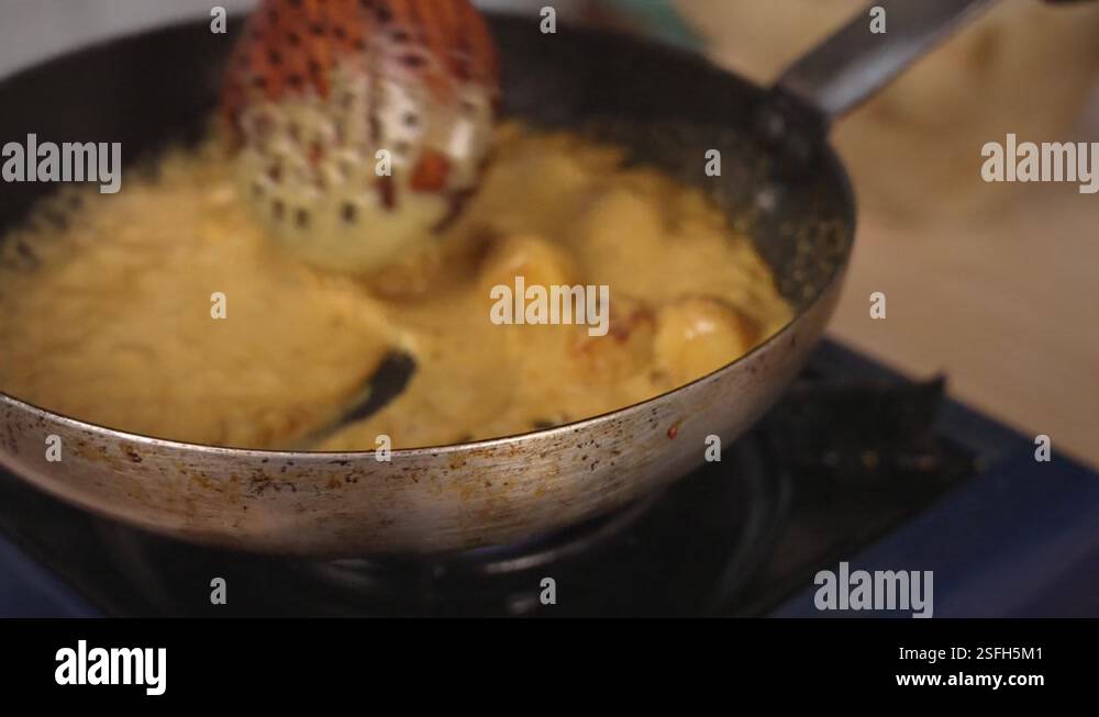 Professional chef using wooden mixing spoon stirring the delicious ...