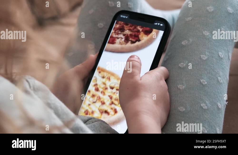 Ordering takeaway food using a smartphone at home, close-up. Little ...