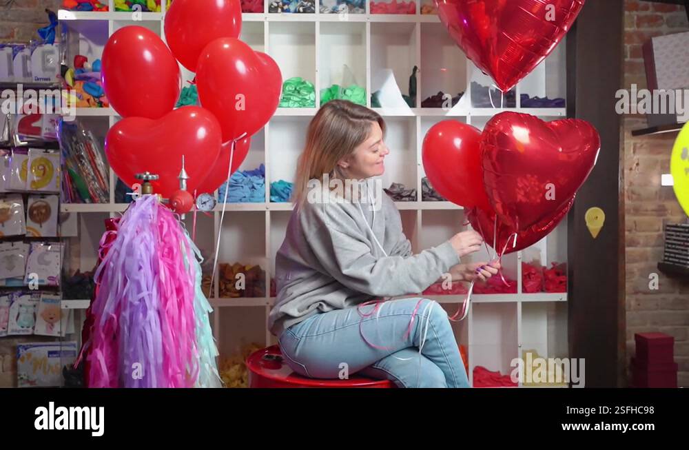 aerodesigner.the woman composes a composition of red balloon shaped ...