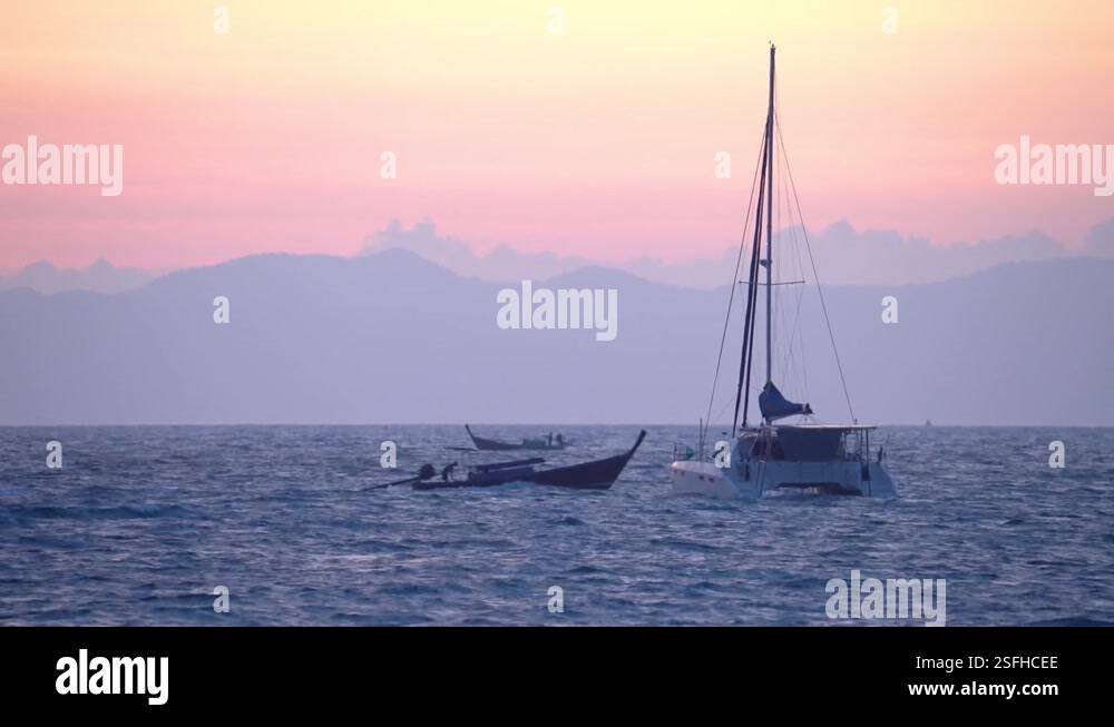 Traditional Boats Passing By Yacht Floating In The Middle Of The Sea At ...
