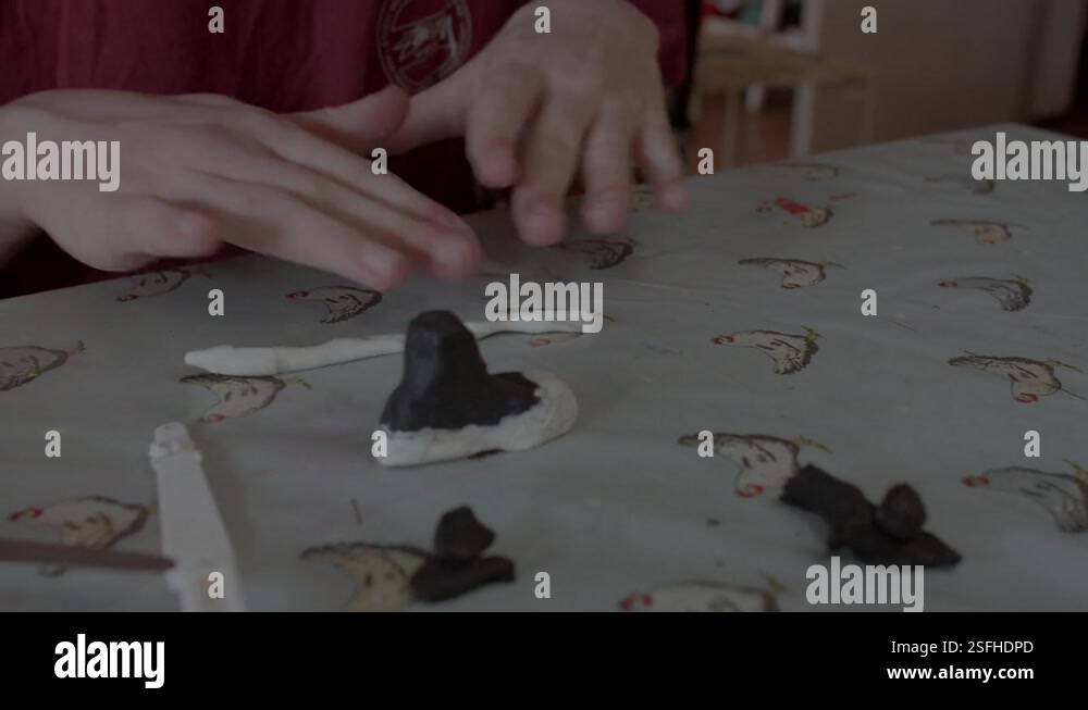 Closeup schoolboy hands are made repetitive movements, modeling clay ...