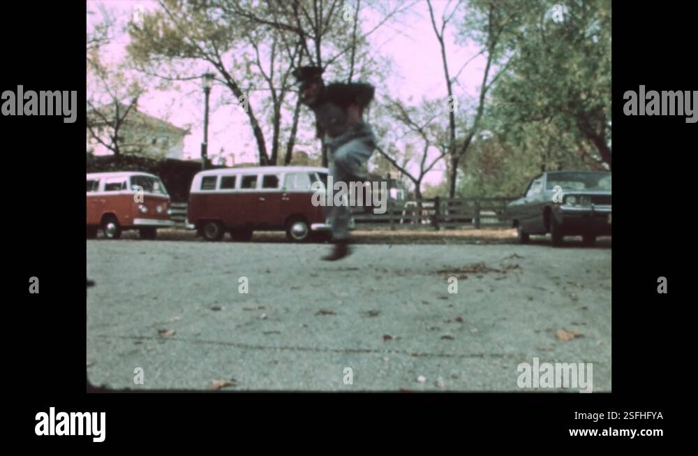 1970s: Man hopping in parking lot. Man popping balloon on van. Ladies ...