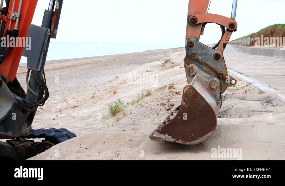 Digger on a beach from the side with the ocean in the background Stock ...