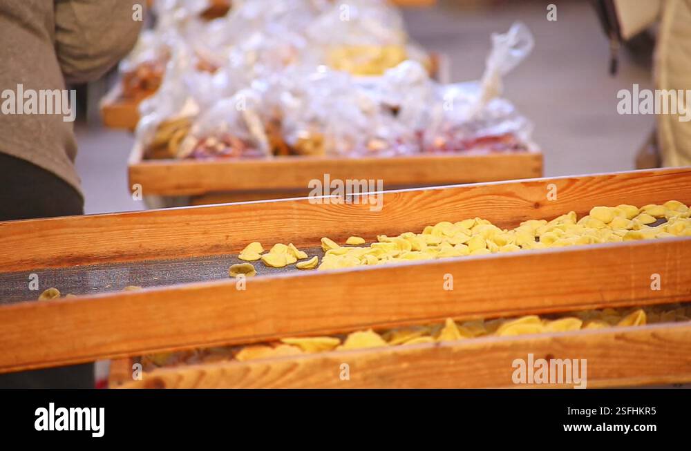 Italian lady selling and preparing orecchiette pasta at local market ...