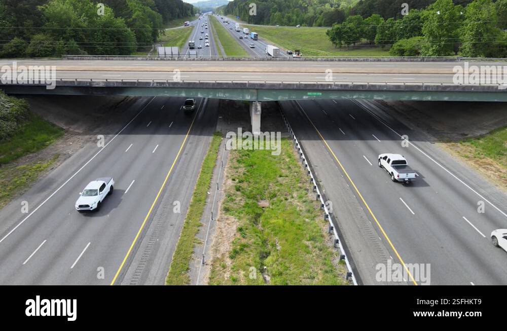 Vehicles passing under an overpass on a divided highway. Busy ...