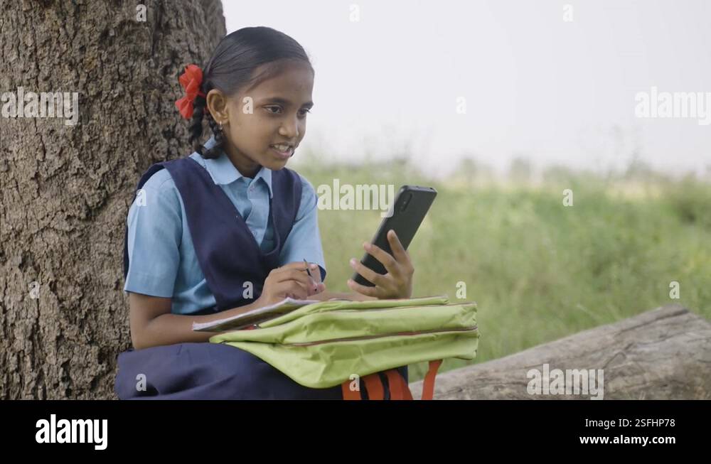 Village listening online class from mobile phone near agriculture farm ...