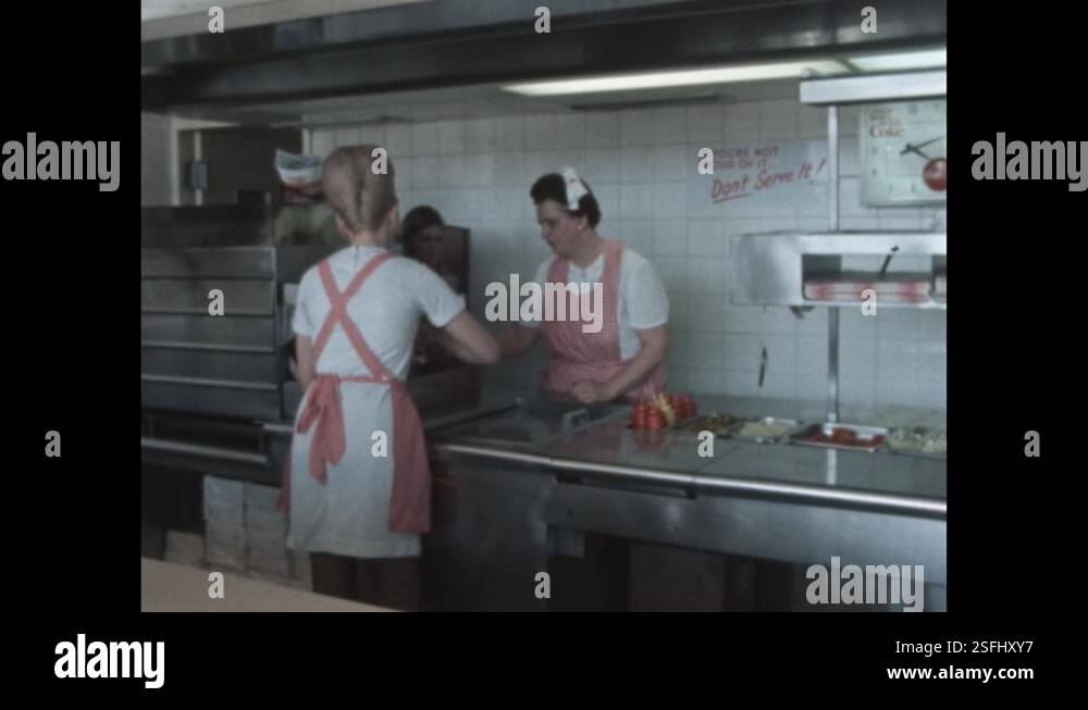 1960s: ladies work in commercial kitchen. Chef gives lady tour of ...