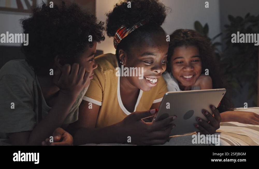 Young Aunt Reading to Siblings in Bed Stock Video Footage - Alamy