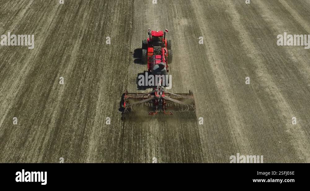 Tractor sowing seeds with seeder driller in field. Process of sowing ...