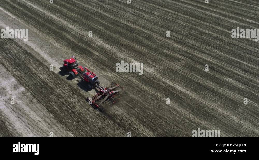 Tractor sowing seeds with seeder driller in field. Process of sowing ...