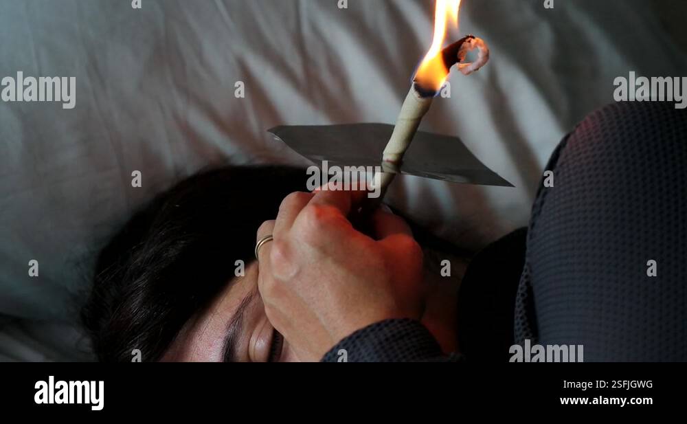 Burning cone ear wax removal ear candling Stock Video Footage - Alamy