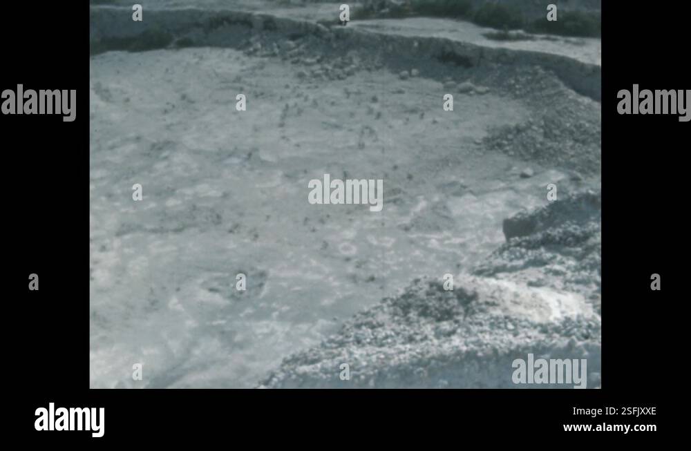 1960s: A sandy desert basin. Focus on a person looking around the basin ...