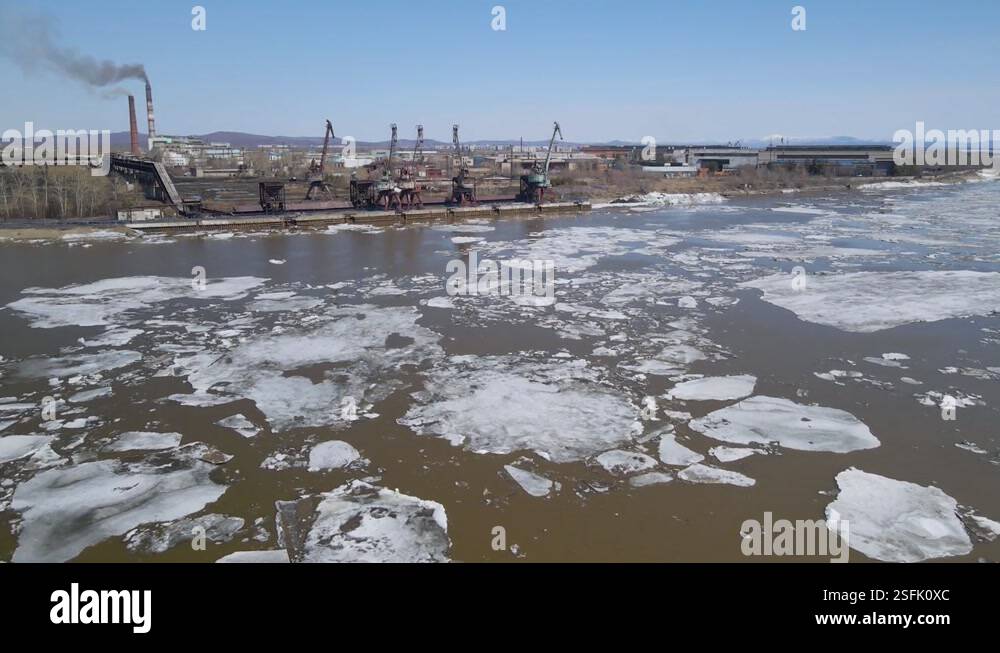 Ice Drift Occurs on a River next to the Port with Big Cranes and ...