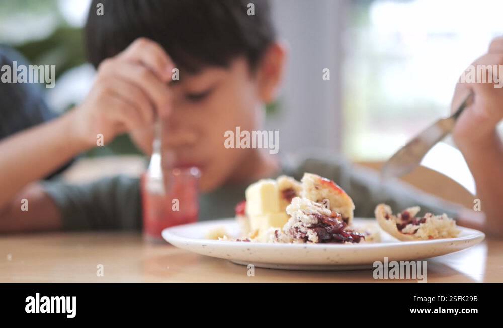 Asian boy eating a sweet scone with a happy expression Stock Video ...