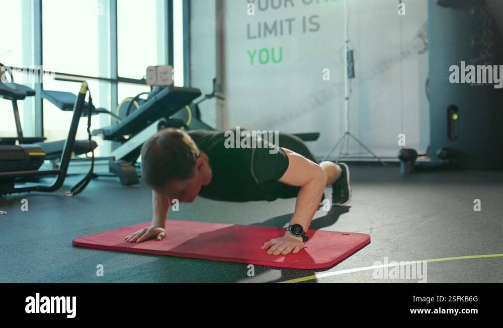 Self-improvement, athletic man performs explosive push ups in the gym ...