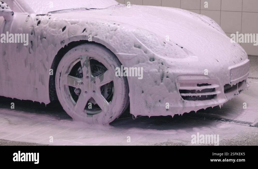 Worker sprays car hood with active foam at car wash service Stock Video ...