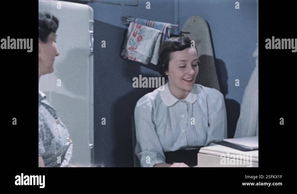 1950s: Girl takes notes in binder and smiles at her Mother. Dining room ...