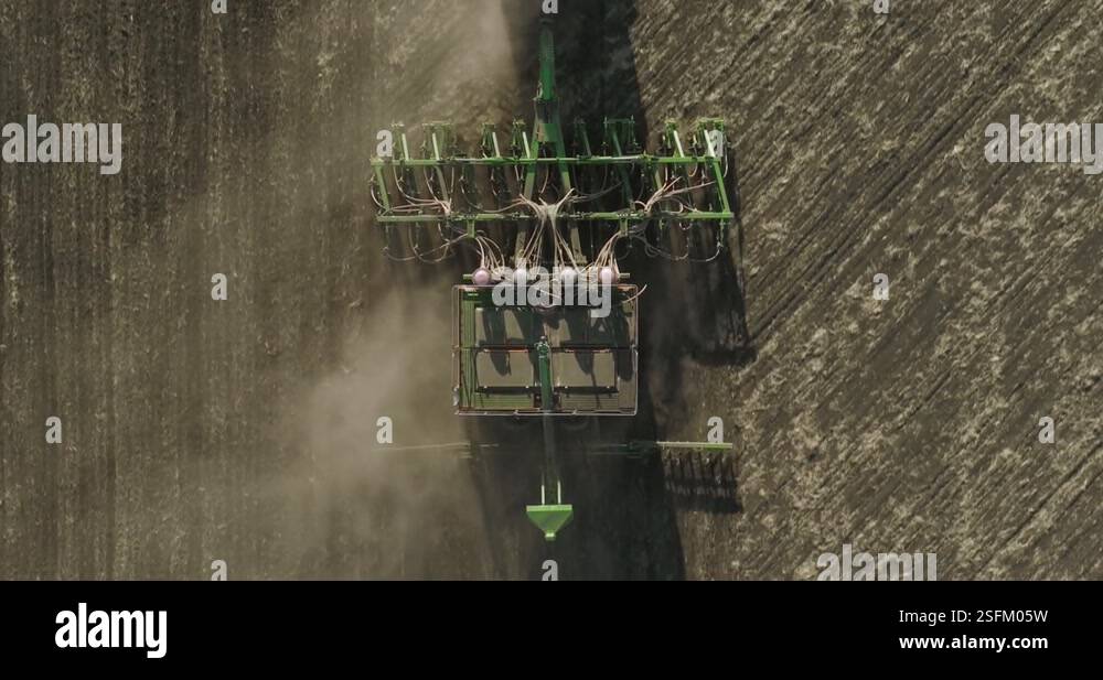 Tractor sowing seeds with seeder driller in field. Process of sowing ...