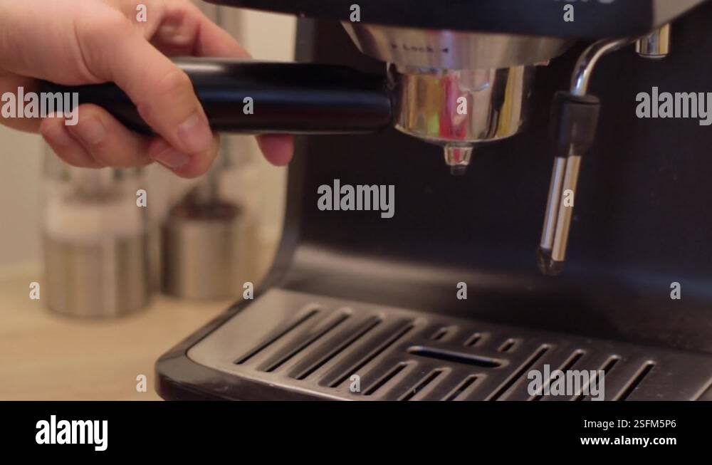 Inserting freshly grinded coffee beans inside portafilter into machine ...