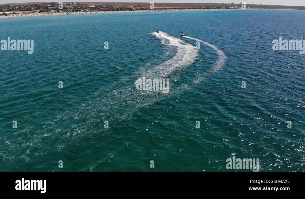 Water activities for tourists by the sea. Riding on a small boat behind ...