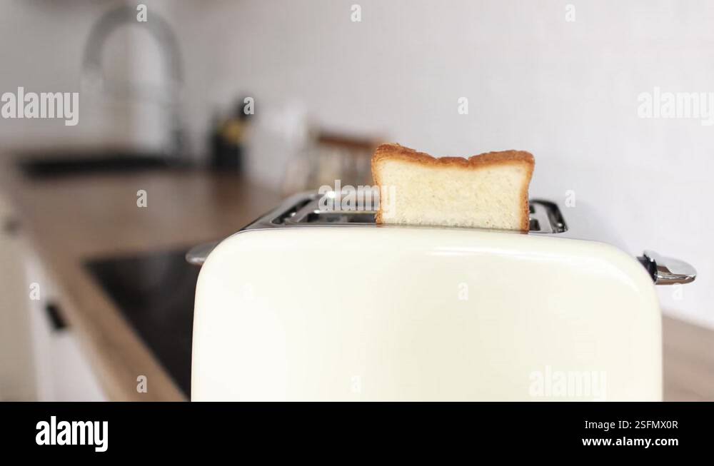 close up of hand are puting toasts bread in toaster in the kitchen ...