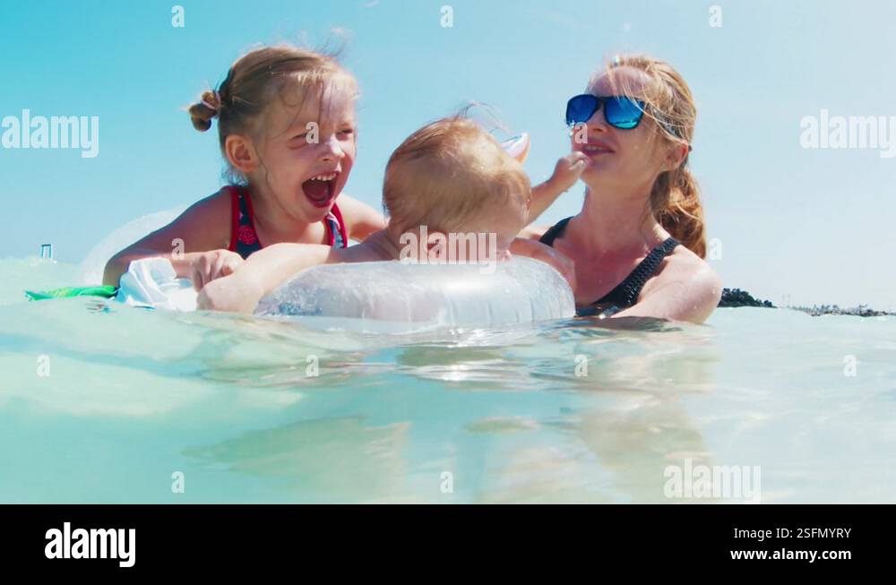 Water fun. Extended family with kids swim in the warm calm sea and have ...