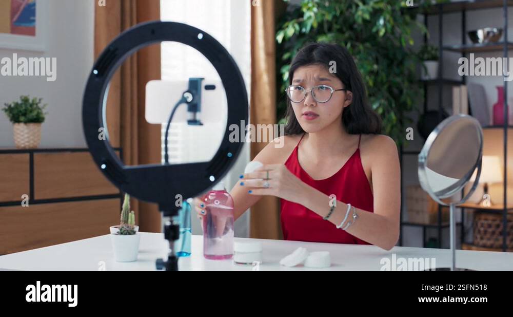 A beauty influencer records a vlog on social media about her skincare ...