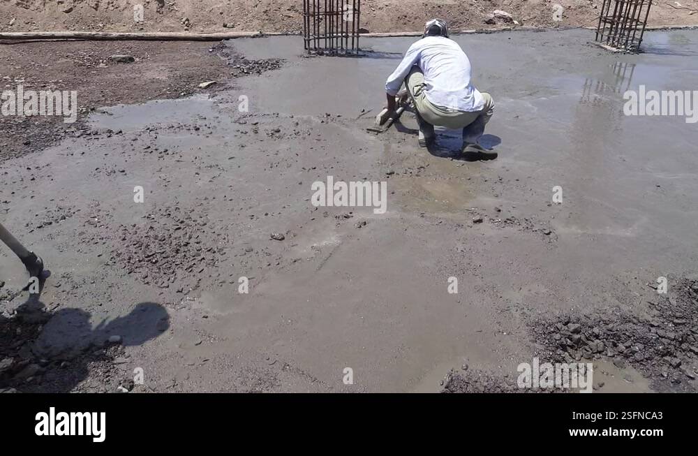 A worker Leveling PCC Foundation Concrete slab On A New Building Stock ...