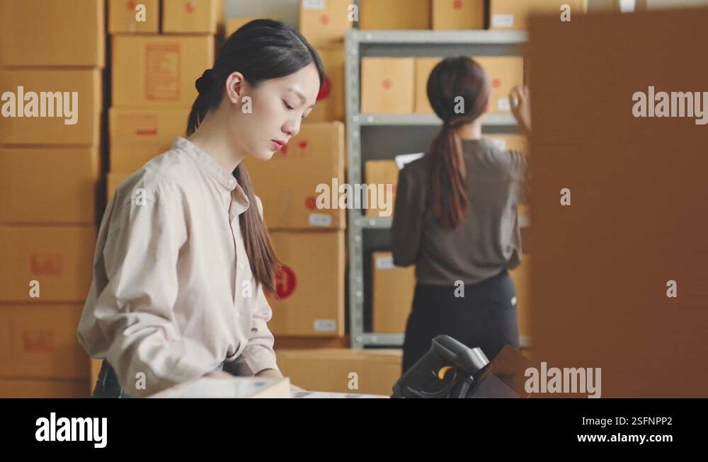 Asian woman working at online store warehouse, using barcode reader Stock Video Footage - Alamy