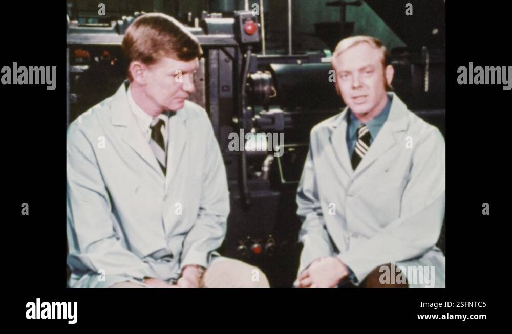 1970s: Men sit and speak in factory. Man works with machine. Man ...