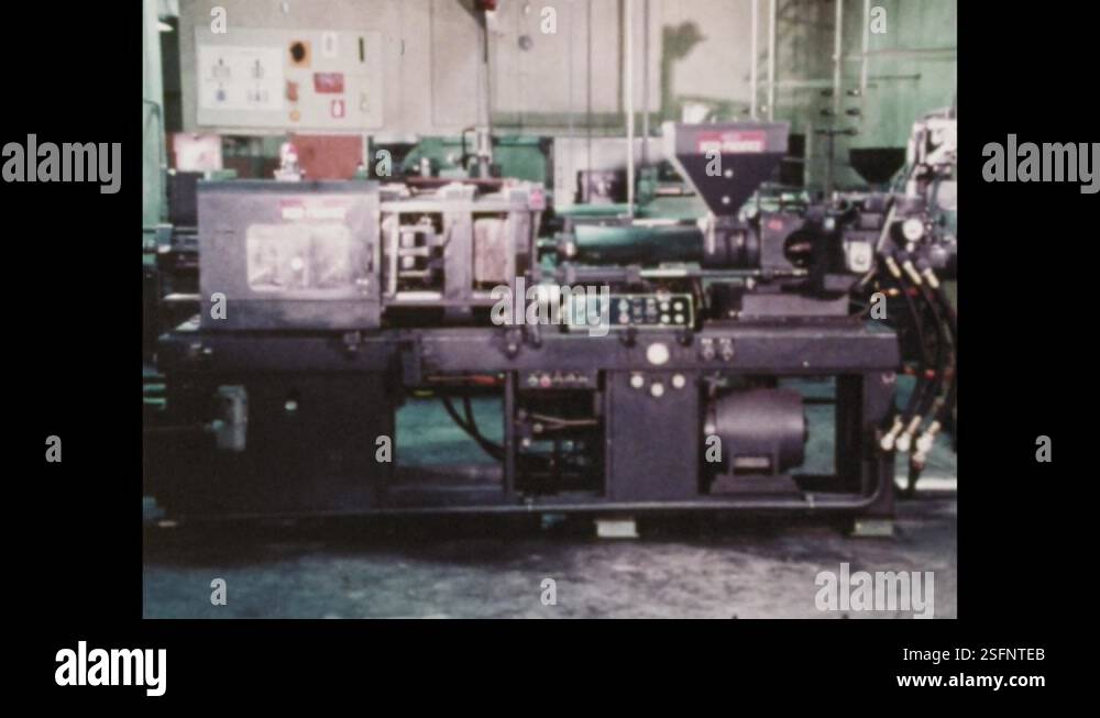 1970s: Man speaks. Machine in factory. Man holds parts. Water on floor ...