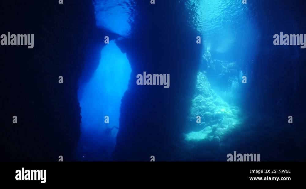 sun light rays beams underwater cave scuba divers to see ocean scenery ...