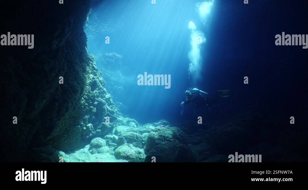 sun light rays beams underwater cave scuba divers to see ocean scenery ...